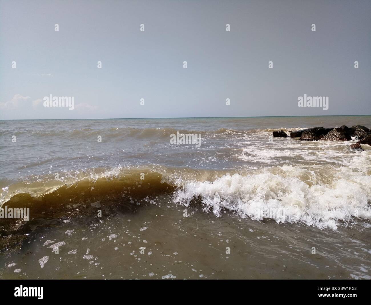 muddy sea water on cloudy day Stock Photo - Alamy