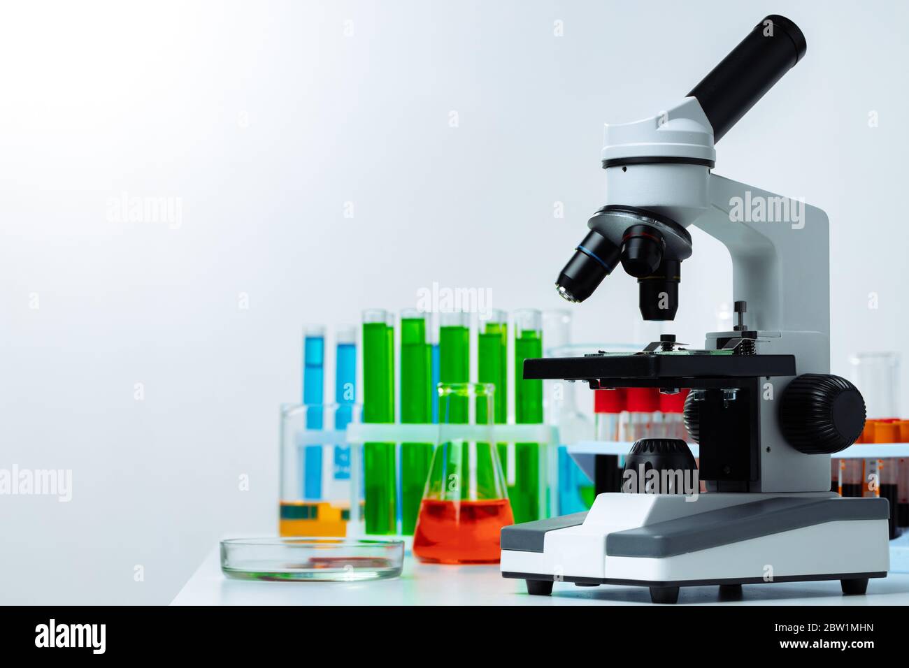 Laboratory microscope with colorful test tubes close up Stock Photo - Alamy
