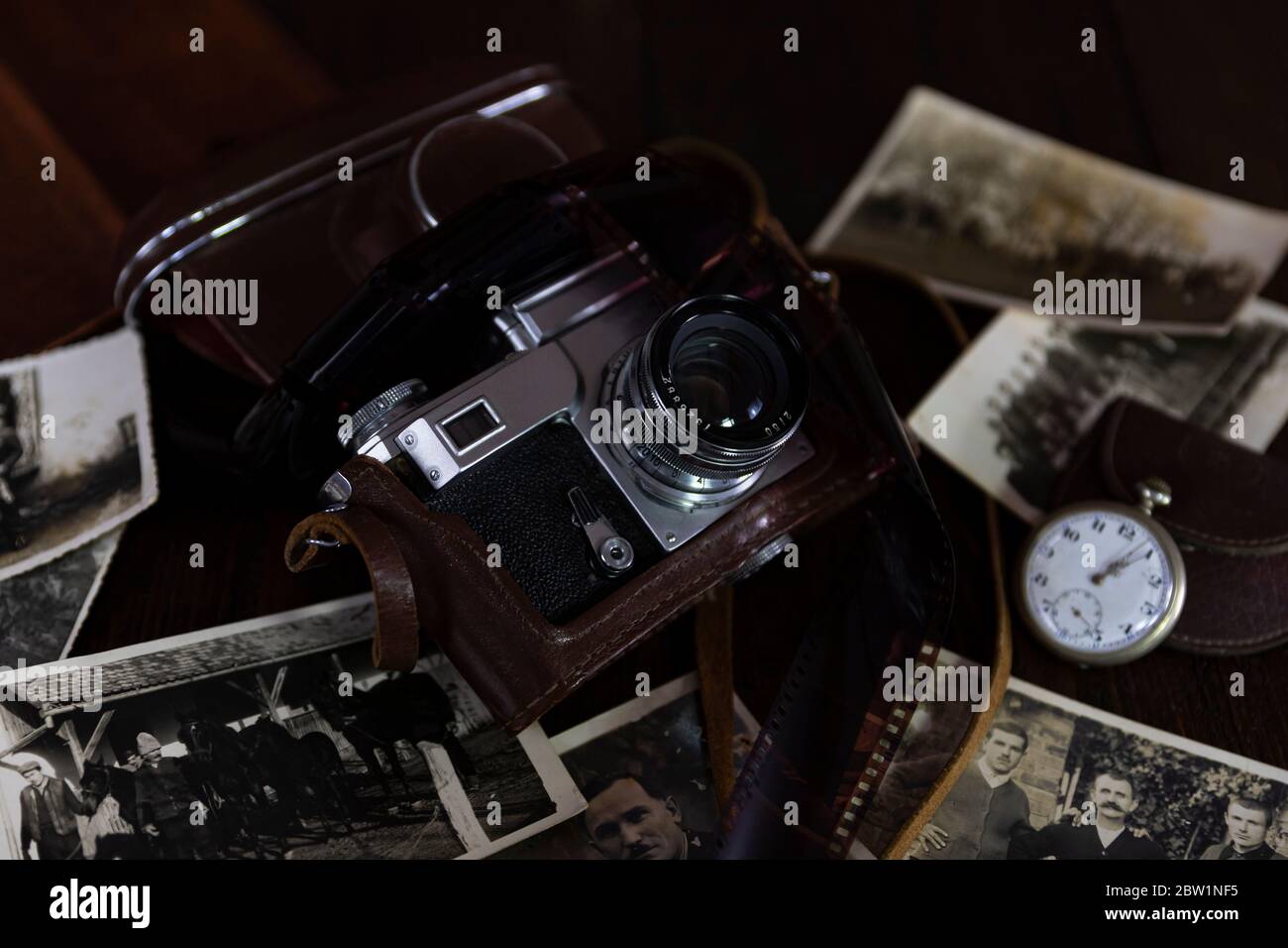 Vintage film camera and old photographs on a rustic surface Stock Photo ...