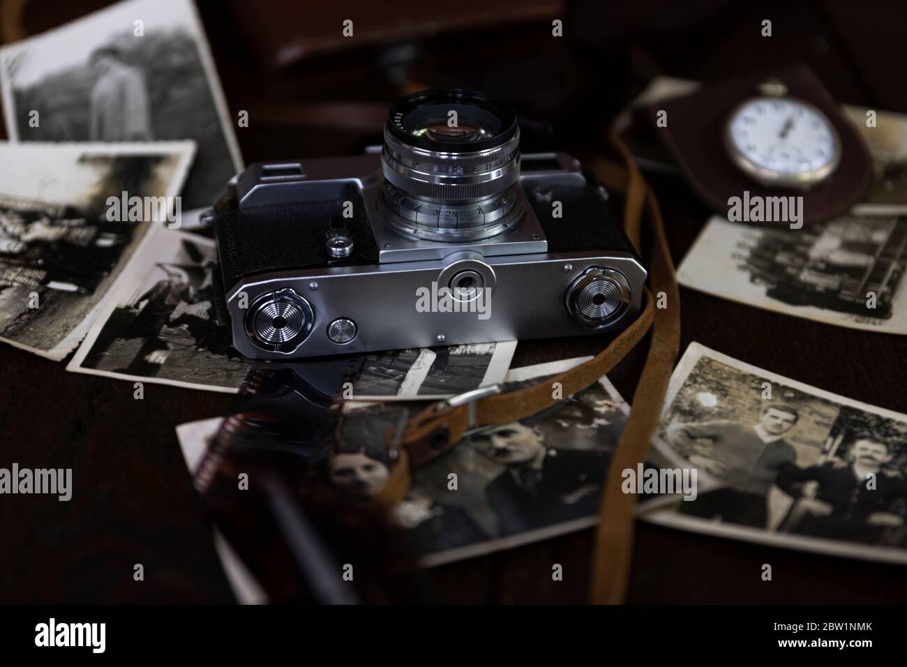Vintage film camera and old photographs on a rustic surface Stock Photo ...
