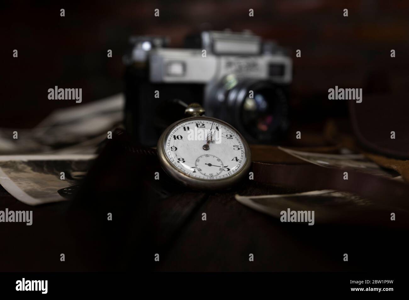 Vintage pocket watch, film camera and old photographs on a rustic ...