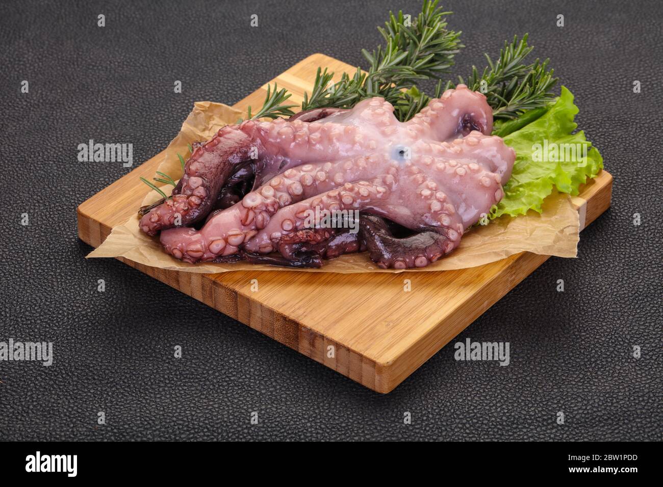 Raw octopus ready for cooking with rosemary Stock Photo - Alamy