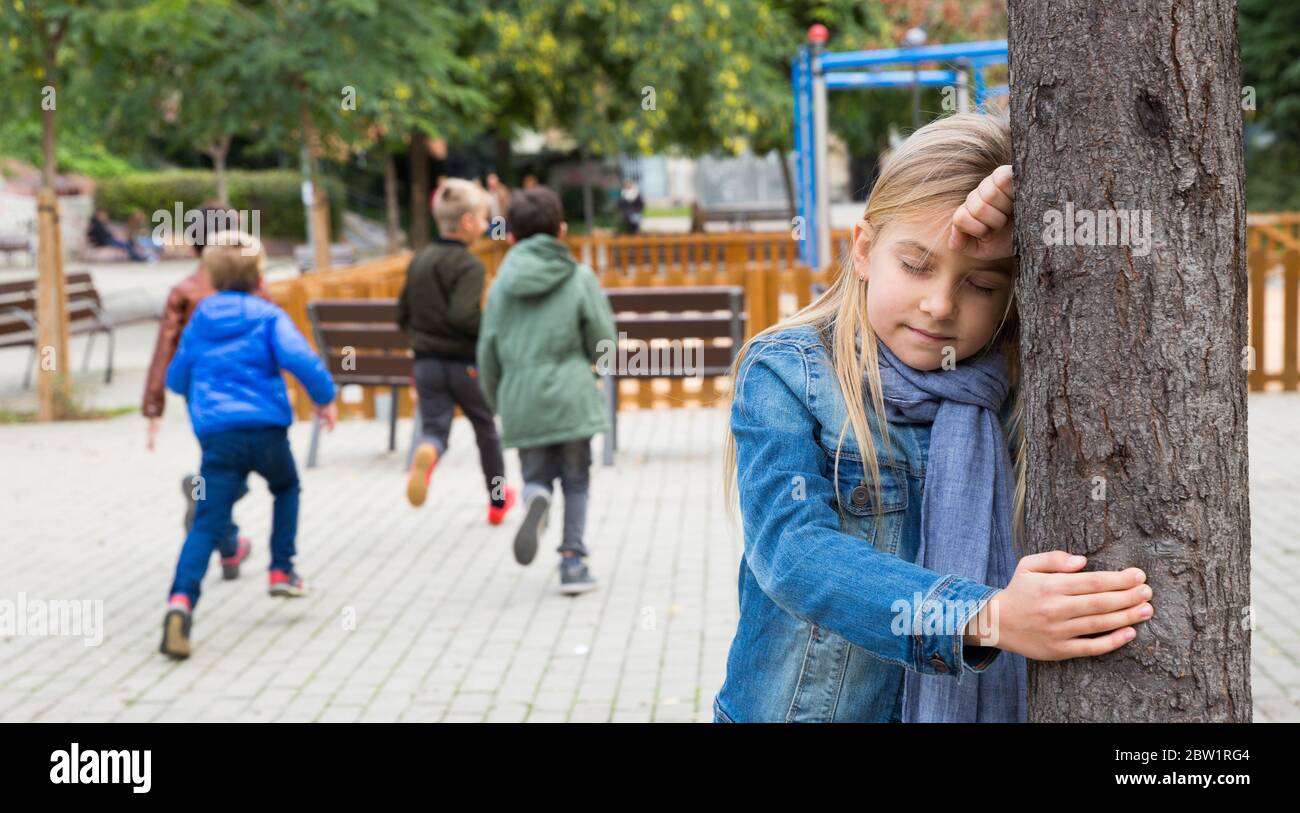 Hide and seek. Preteen girl closing her eyes and counting while other ...