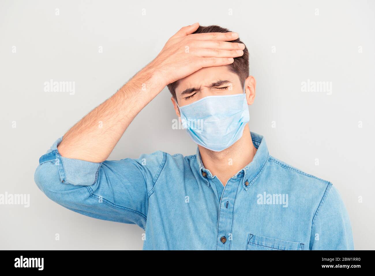 Portrait of ill sick young man in blue shirt wear medical safety face ...