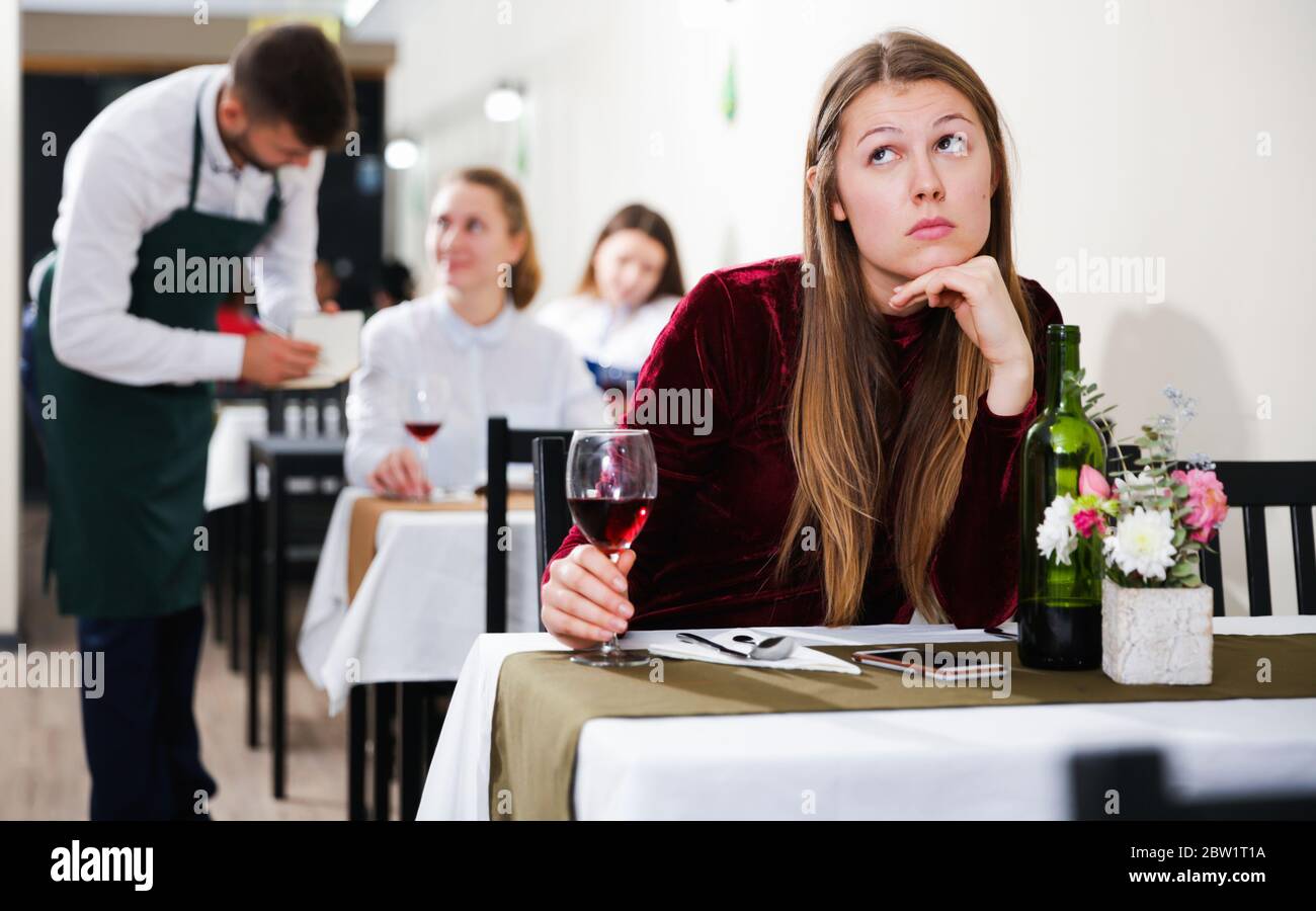 Young female is having dinner alone in the restaurante indoor Stock ...