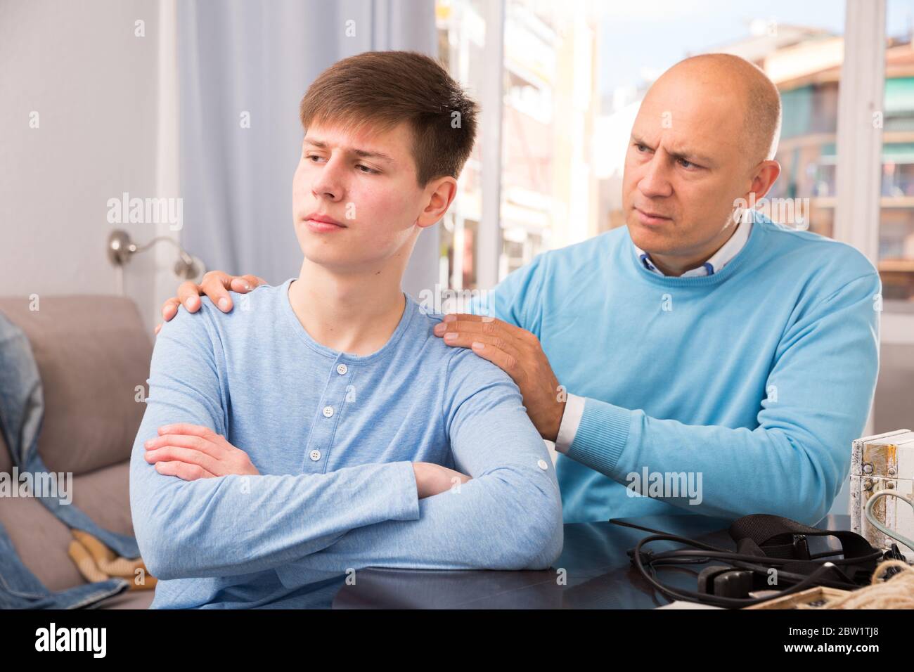 Portrait of father supporting his upset teenage son at home Stock Photo ...