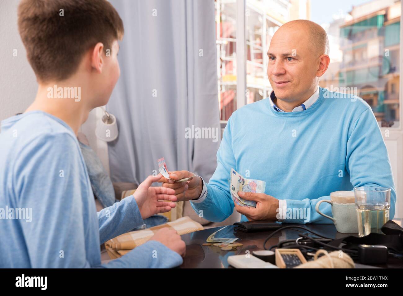 Teenage guy asking his father pocket money at home Stock Photo - Alamy