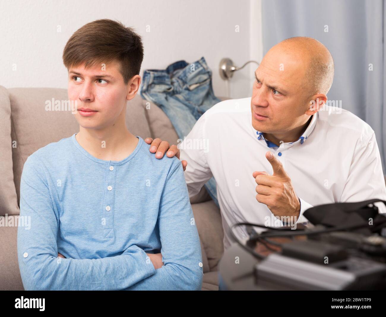Strict father having serious conversation with teen boy at home Stock ...