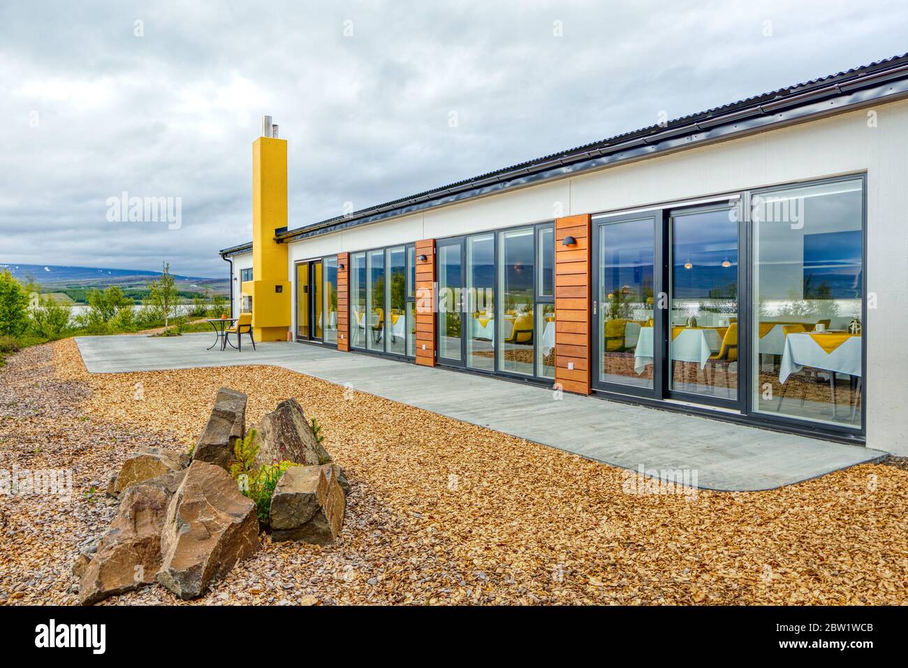 Modern and minimalist hotel exterior with a view of the rooms with huge ...