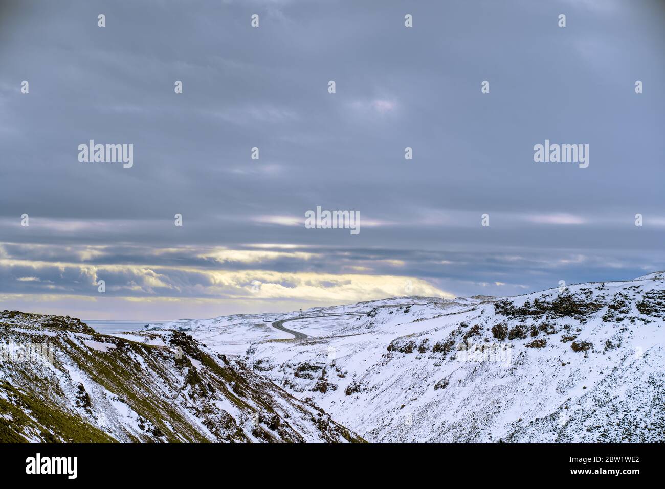 Landscape photograph of snowy mountains with road in background and ...