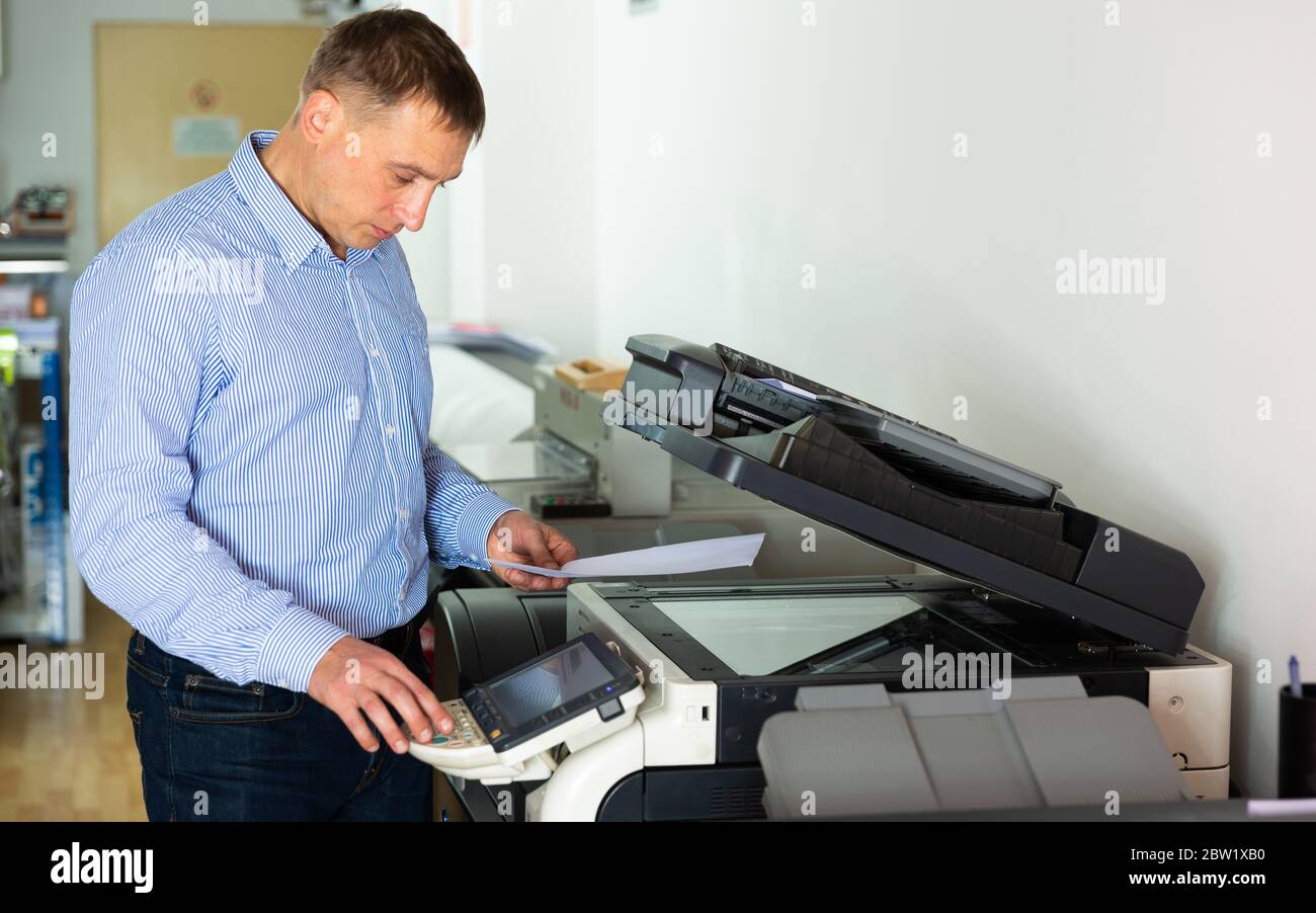 Worker is printing a file, document in the office room Stock Photo - Alamy