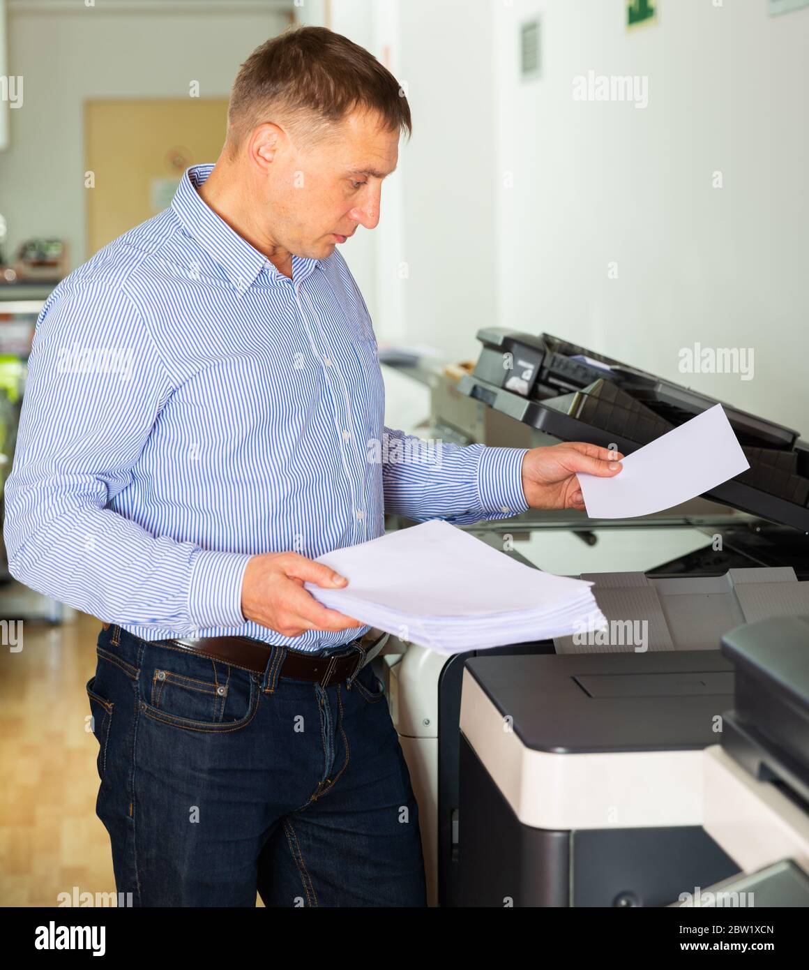 Office worker puts a stack of paper in the printer Stock Photo - Alamy