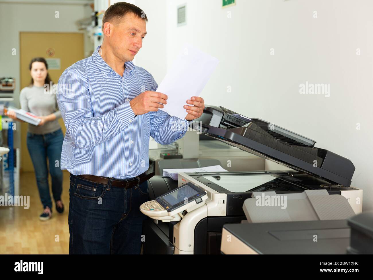 Worker is printing a file, document in the office room Stock Photo - Alamy