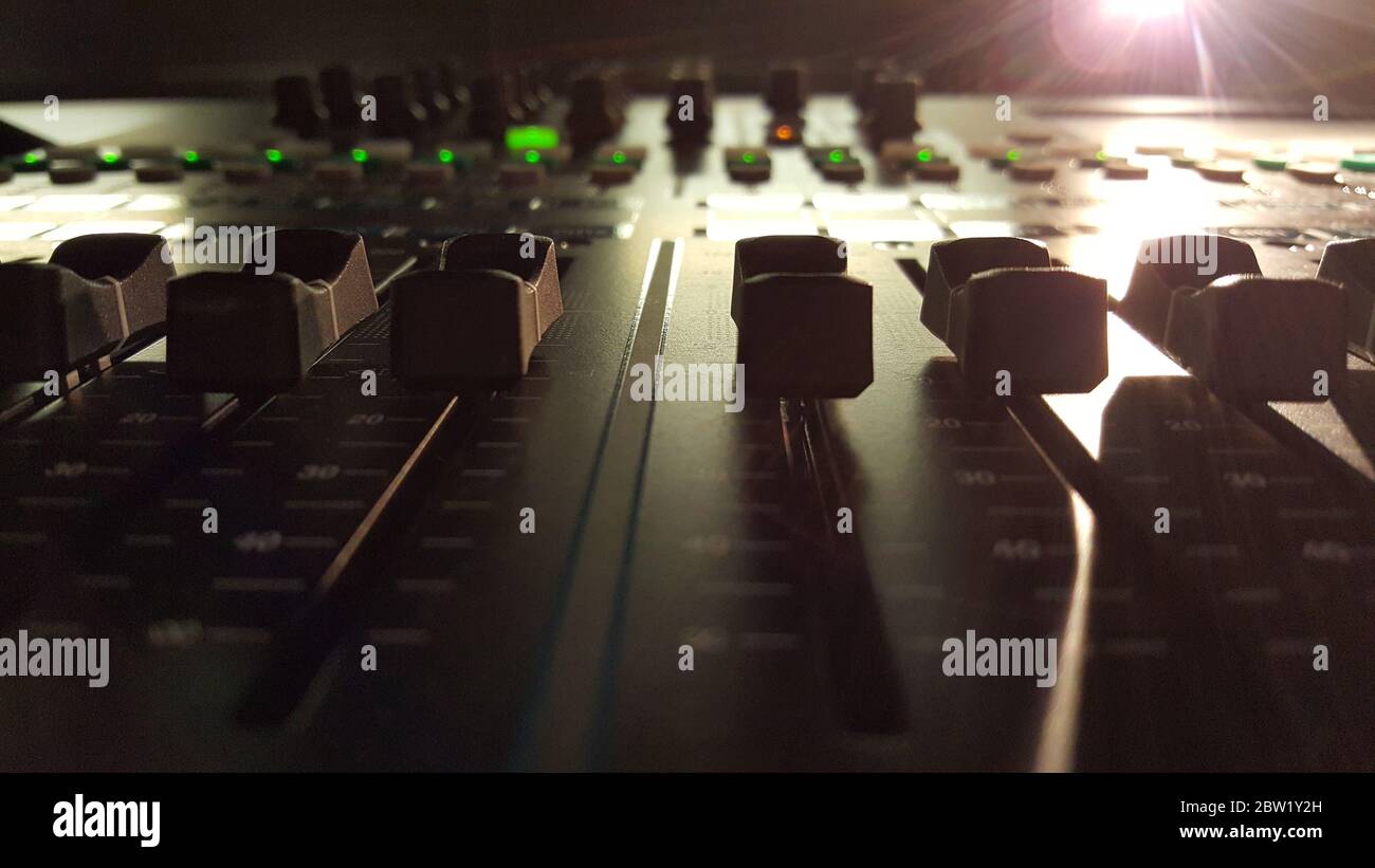 Close up of the faders and other controls of an audio mixing console ...
