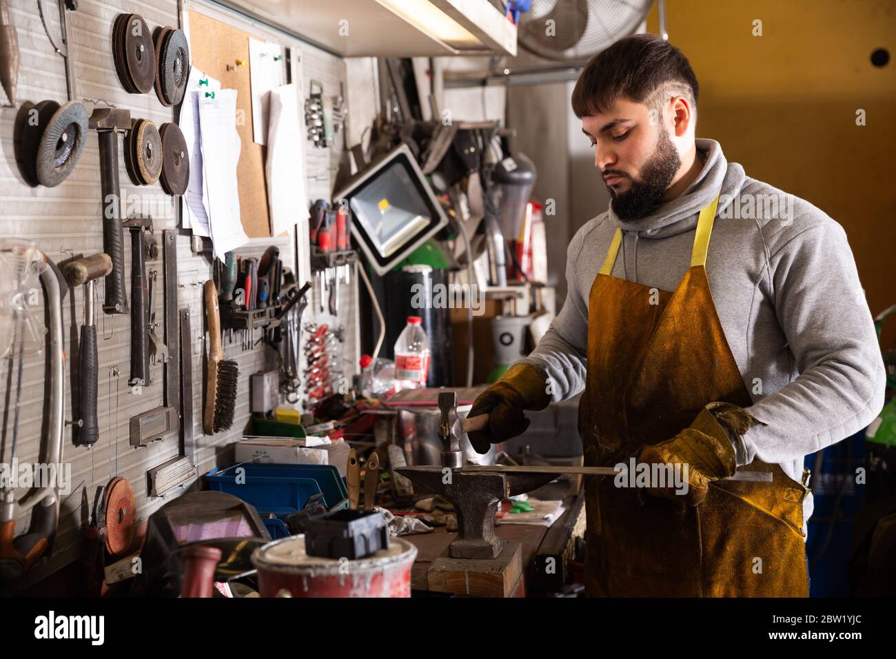 Factory worker handles part on bench vise Stock Photo - Alamy