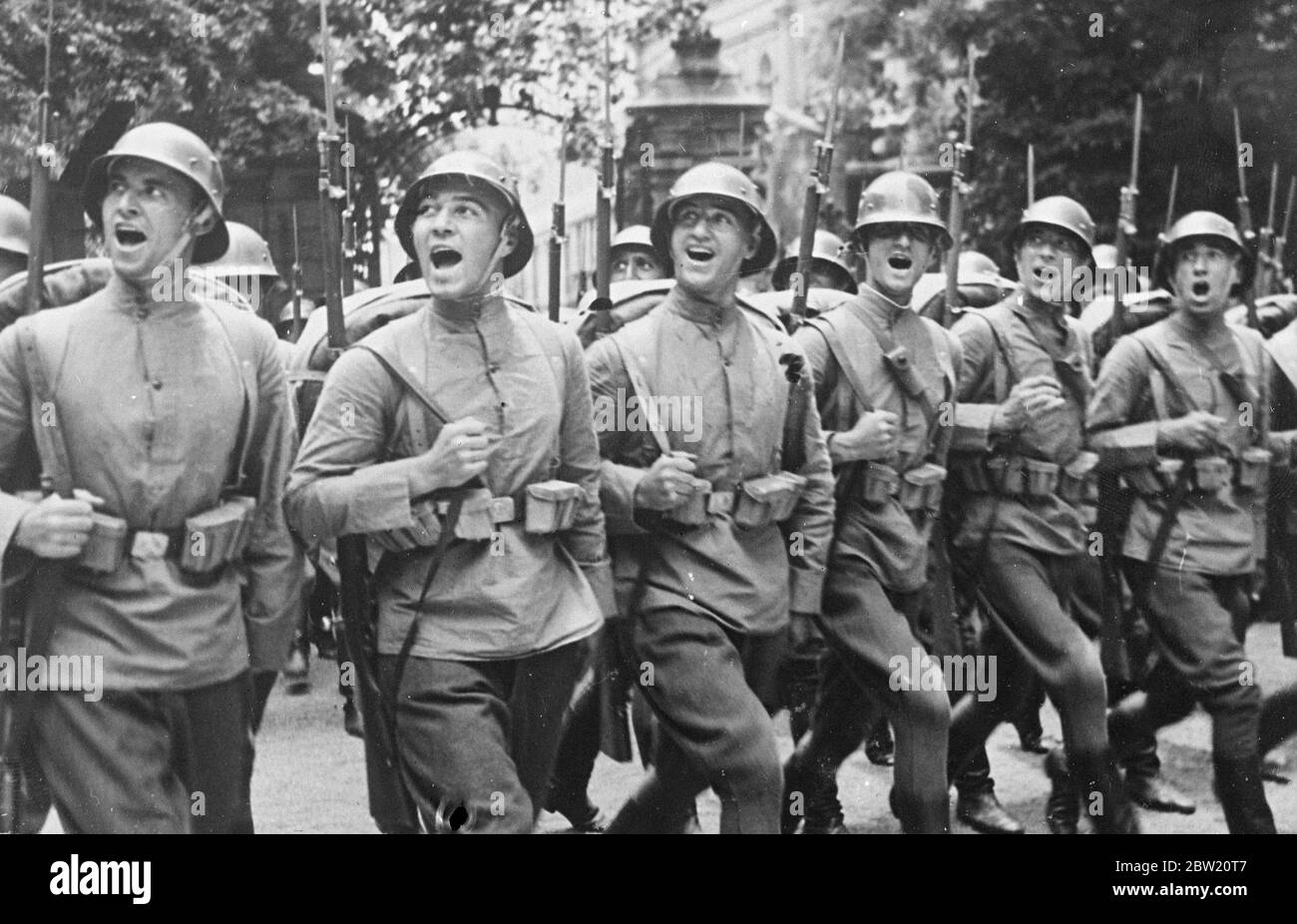 Columns of troops, shouting congratulations, march past King Boris at ...