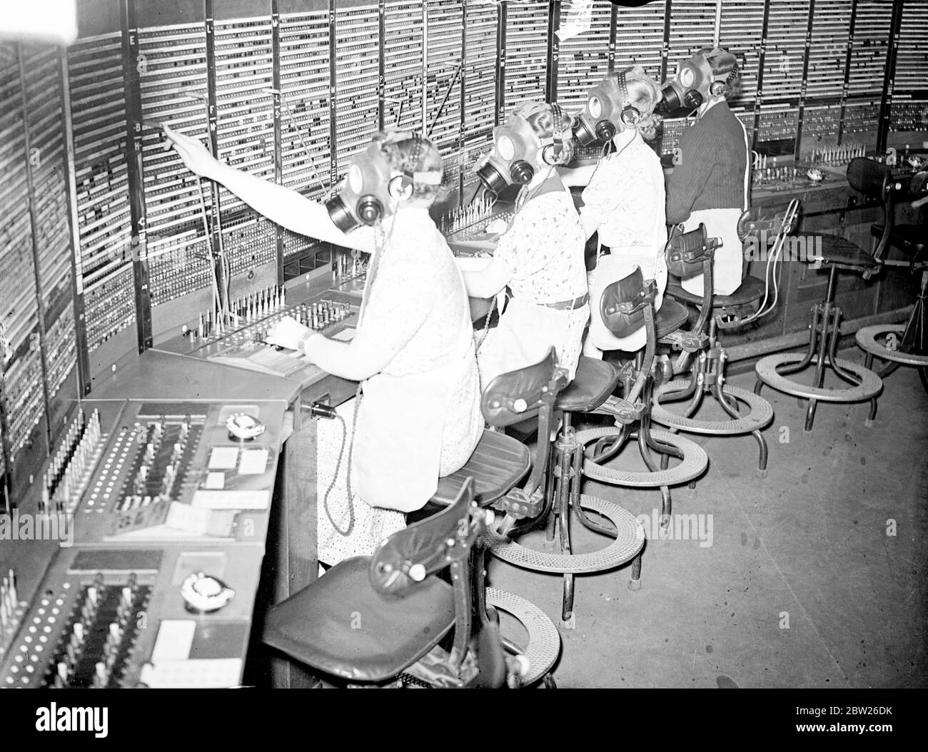 Telephone girls learn to carry on as usual in gas masks. Telephone ...