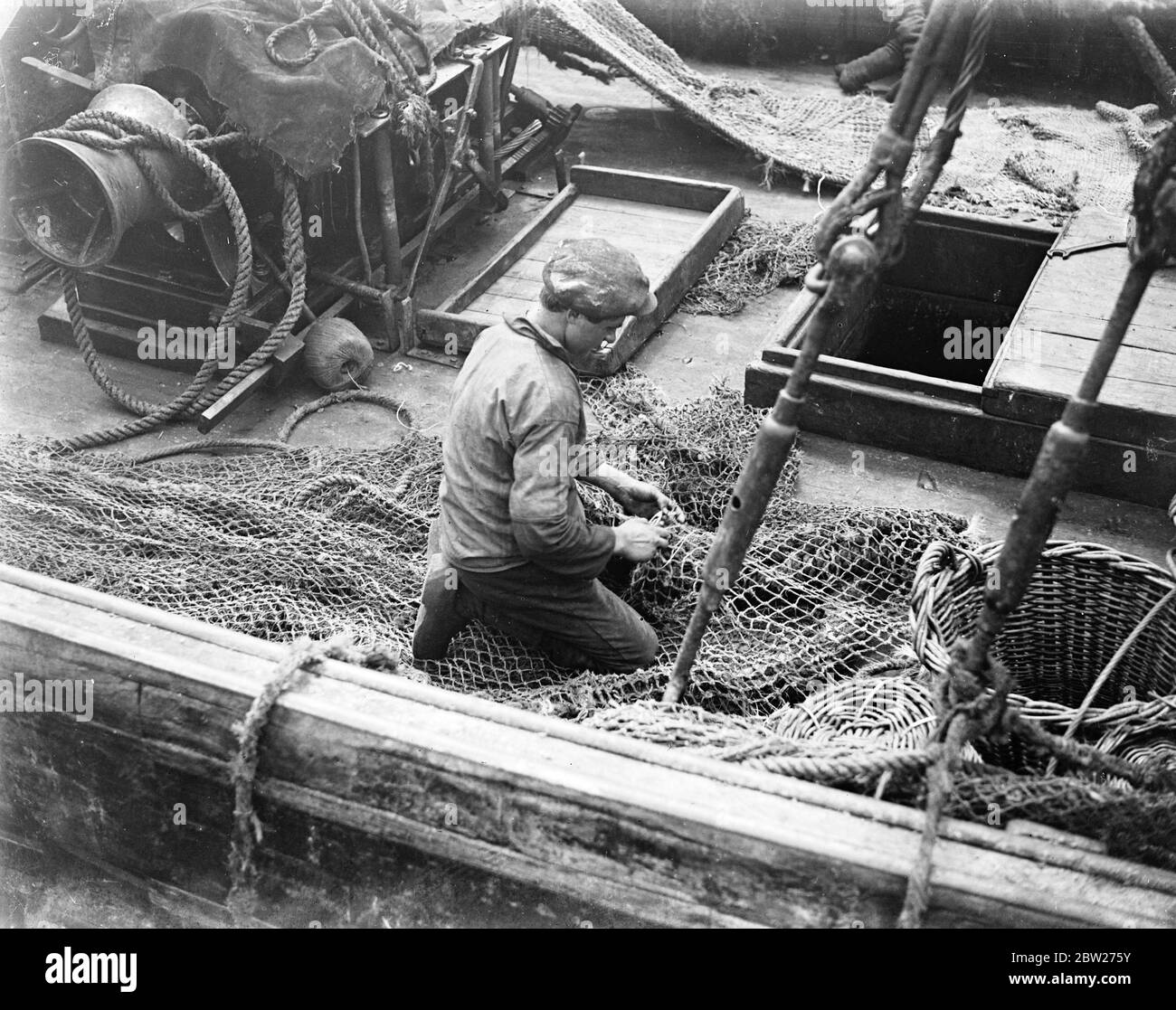 A fisherman mending the nets in Yarmouth, Isle of Wight 1933 Stock ...