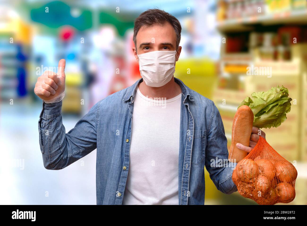 Protected man with mask and gloves with hand with ok gesture buying in ...