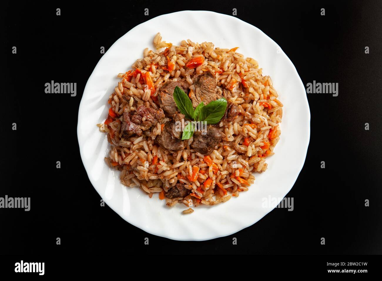 Plate with an asian food pilaw on a black studio background Stock Photo ...