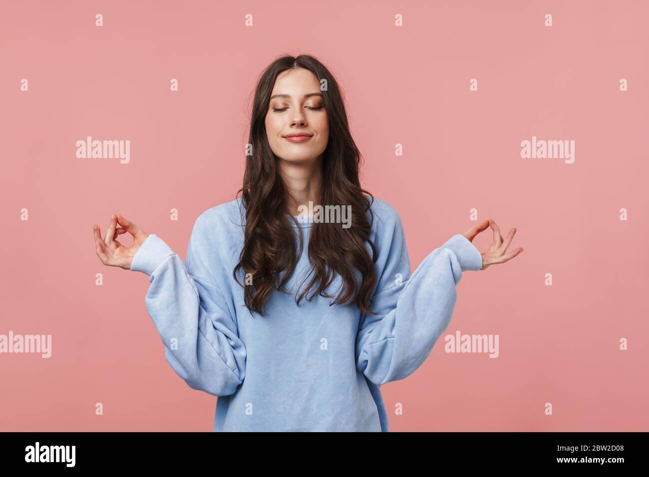 Image of attractive young woman with long brown hair meditating and ...