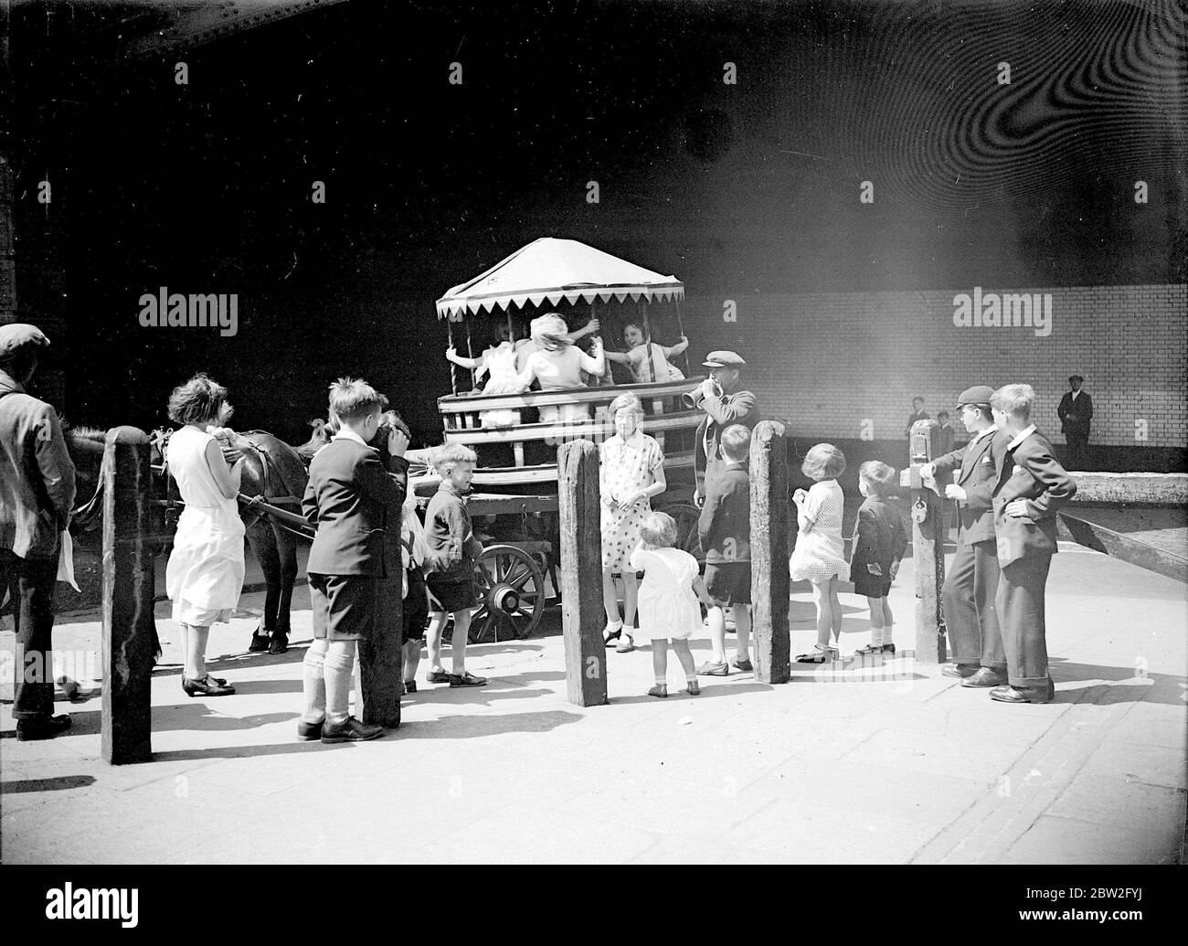 A mobile fun fair, with miniature merry-go-round and a bugie-blowing ...