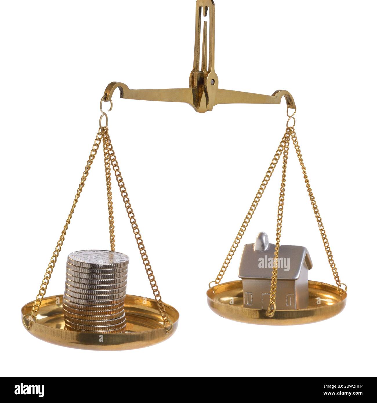 Coins and a house on a brass balance scale Stock Photo - Alamy