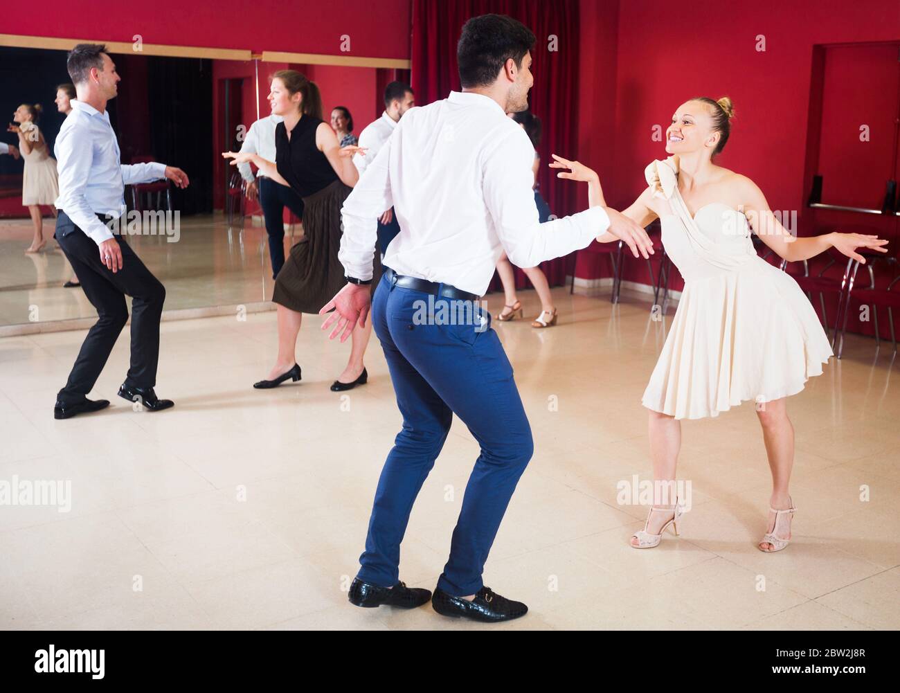 Dancing couples enjoying active dance in modern studio Stock Photo - Alamy