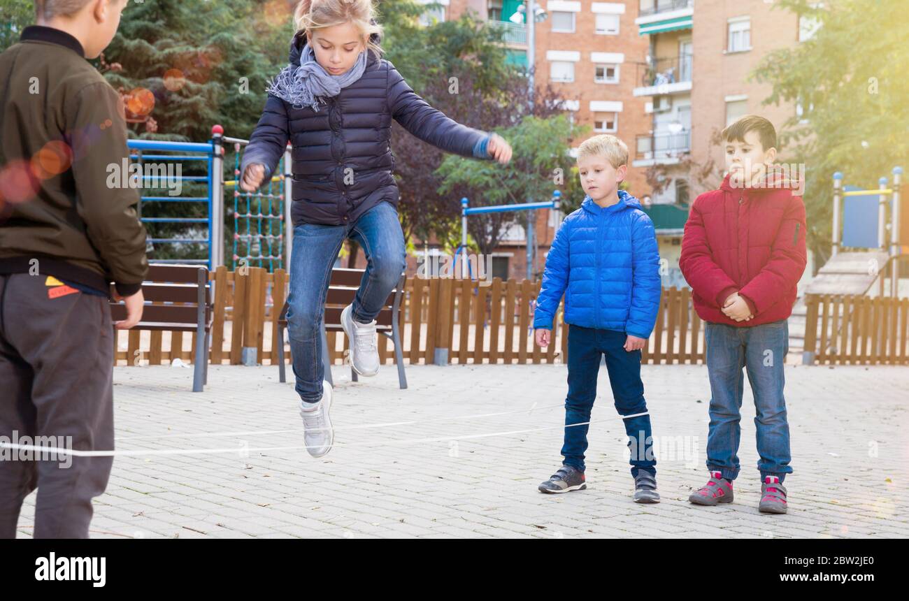 Children jump through an elastic rope in a children playground Stock ...