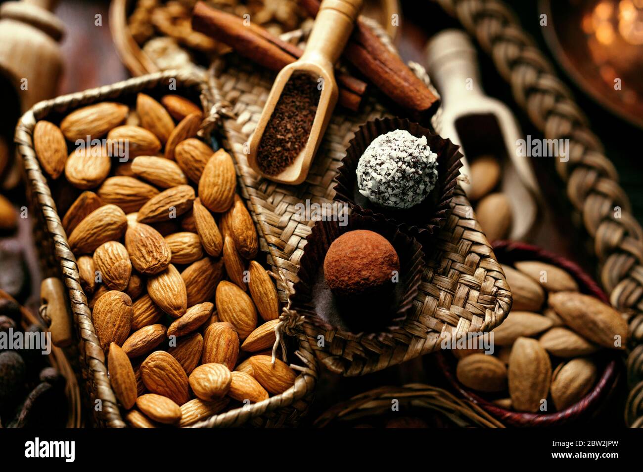 Handmade truffles inside of candy wrapper stand on wicker basket with ...