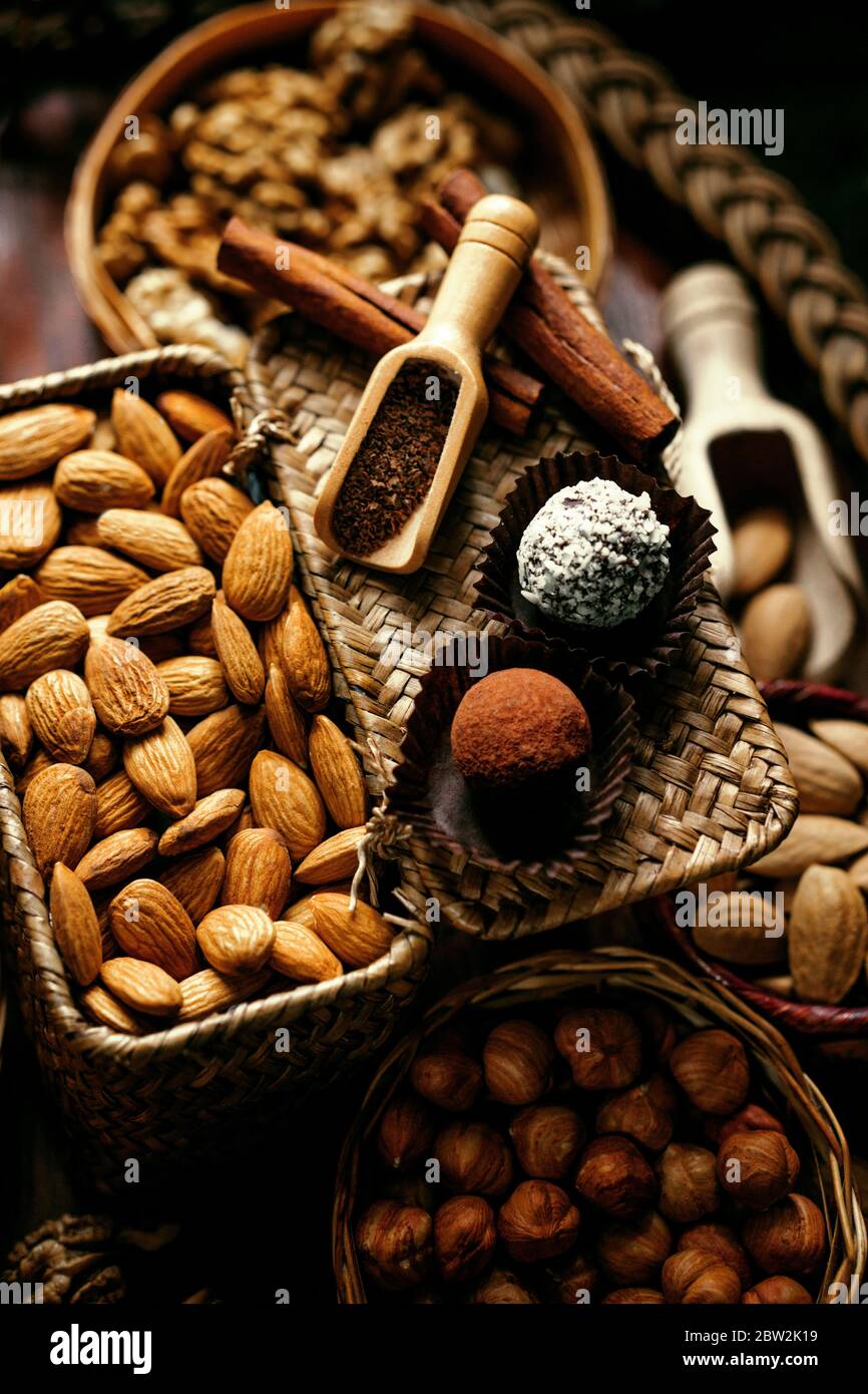 Handmade truffles inside of candy wrapper stand on wicker basket with ...
