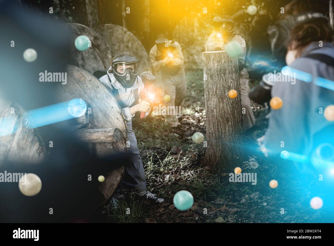 Adult paintball players of opposite teams playing in shootout outdoors ...