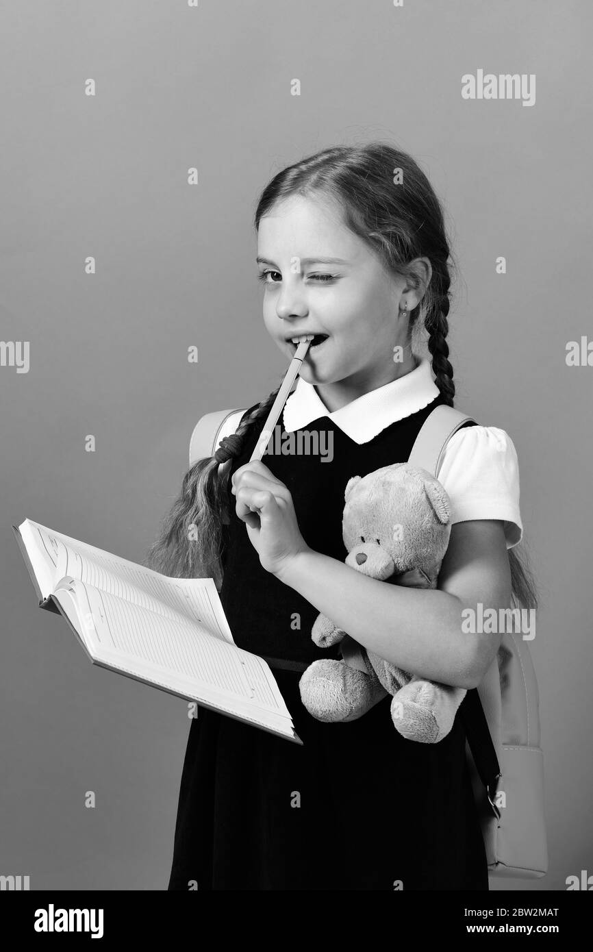 Back to school and education concept. Girl holds teddy bear, open ...