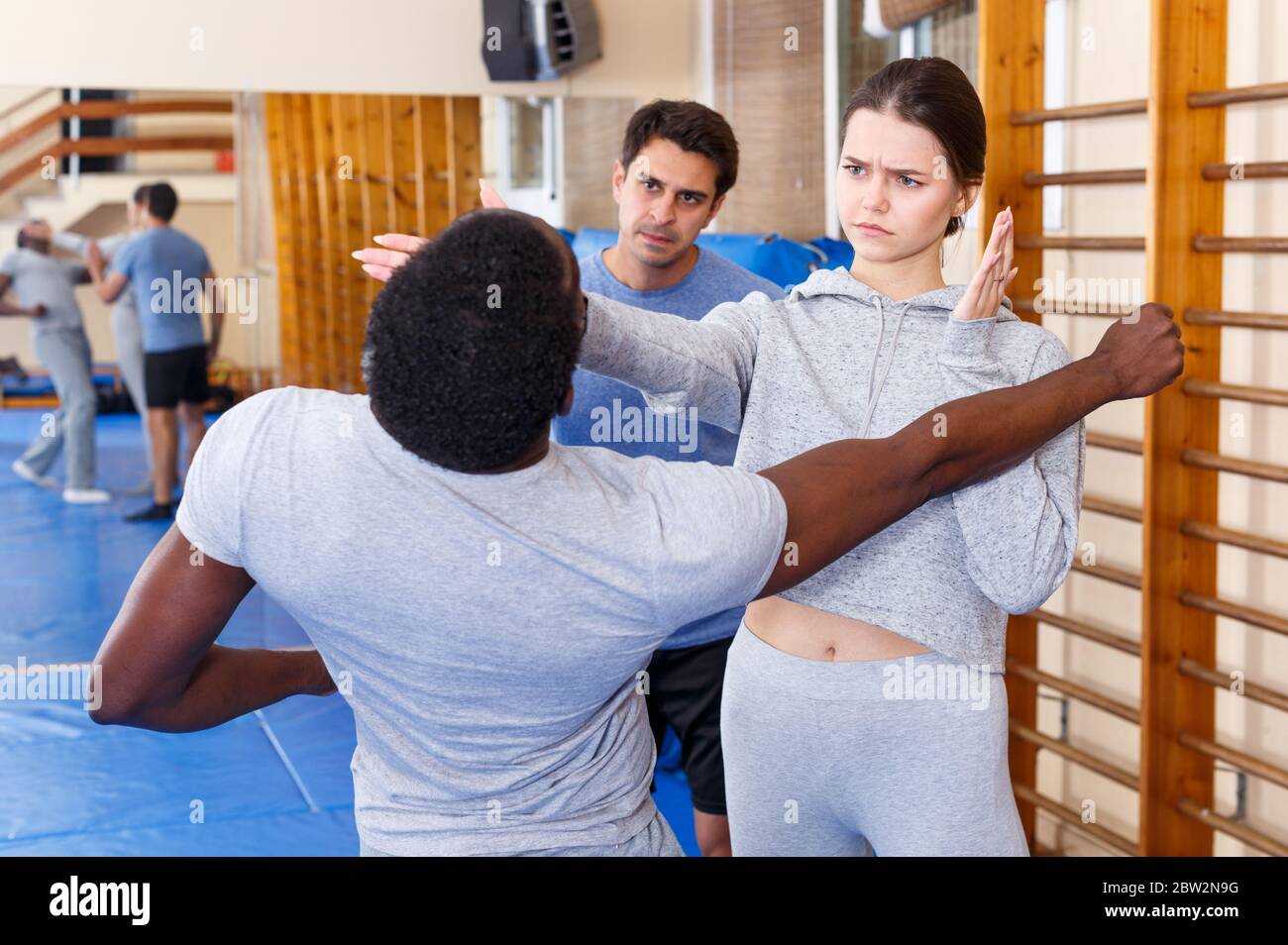 Young people practicing in pair self-defence movements with male ...