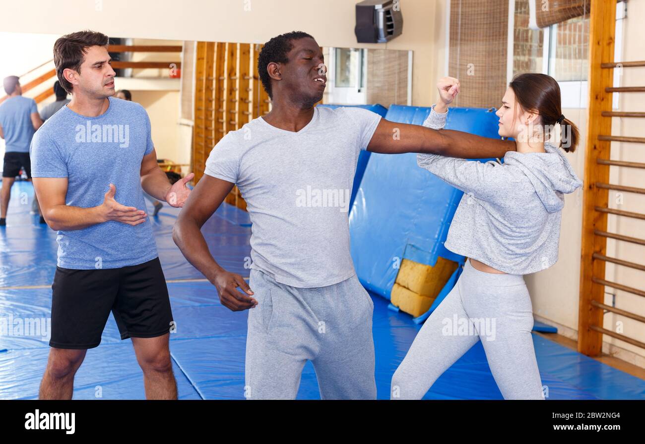 Young people practicing in pair self-defence movements with male ...