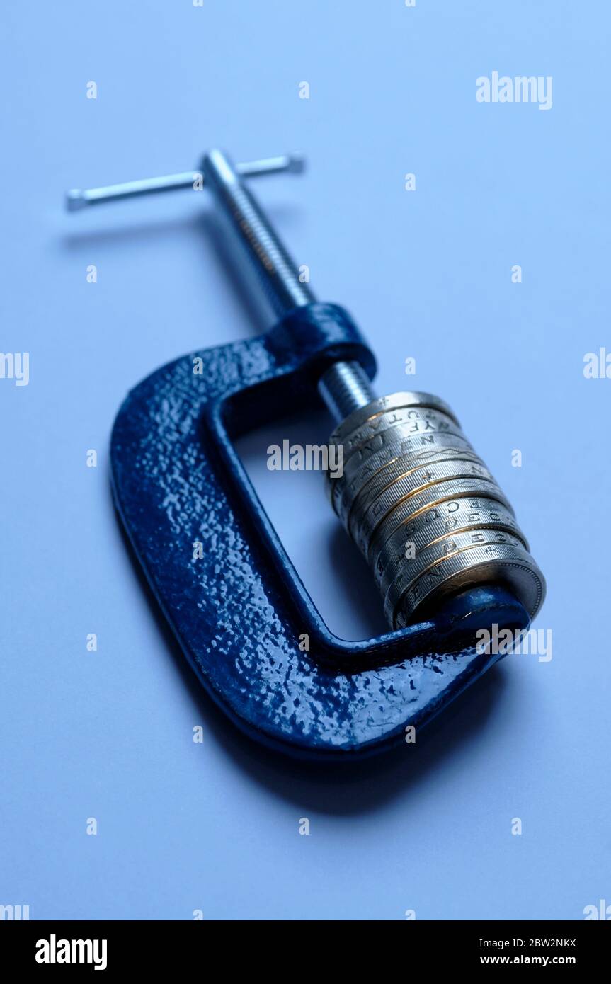 Coins being squeezed in a metal clamp Stock Photo - Alamy