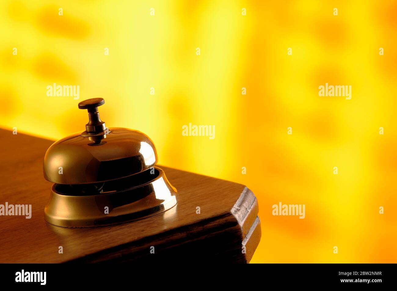 A brass reception bell on an old wooden desk Stock Photo - Alamy