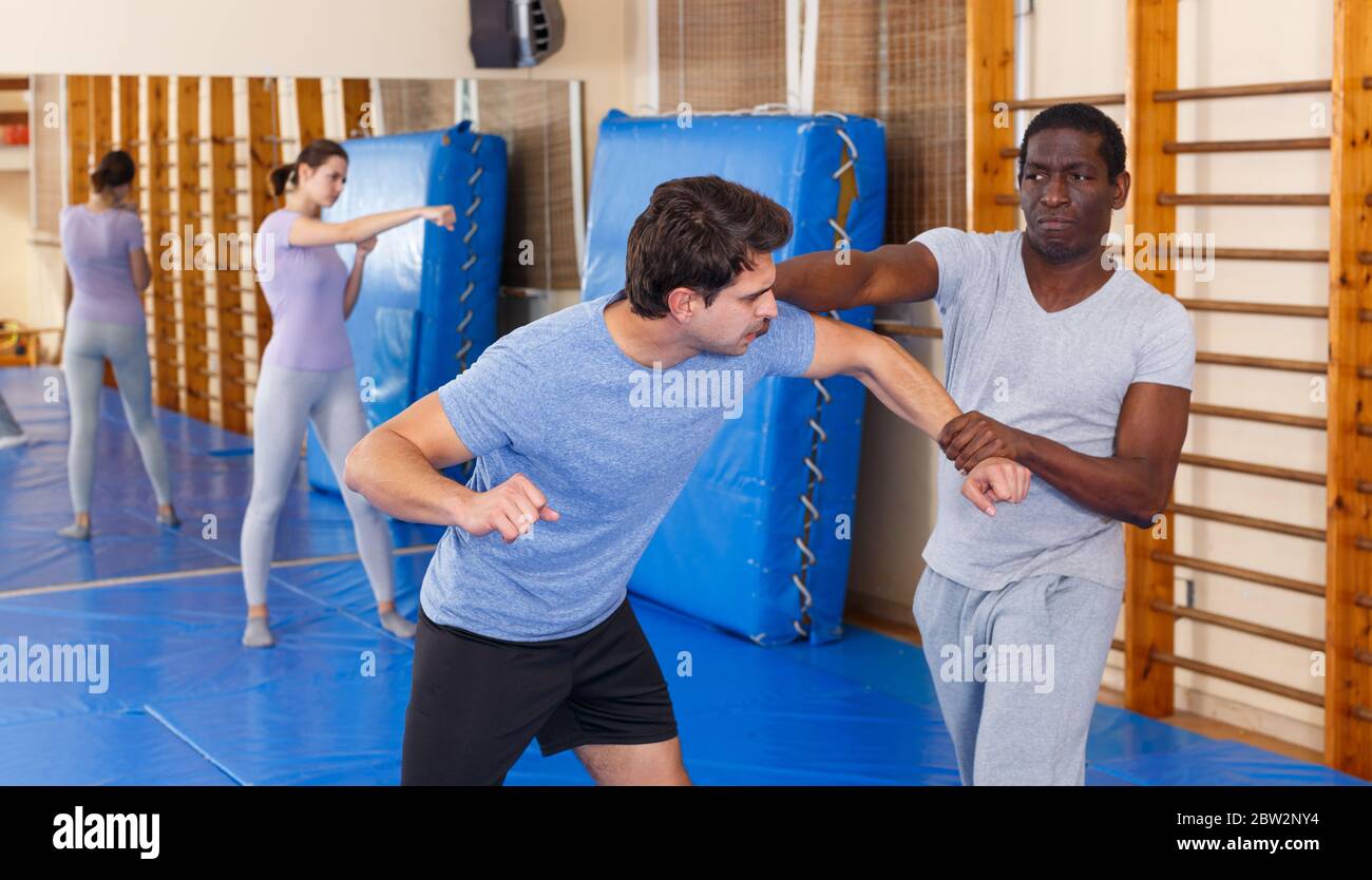 Males training attack movements in pair at self protection workout ...