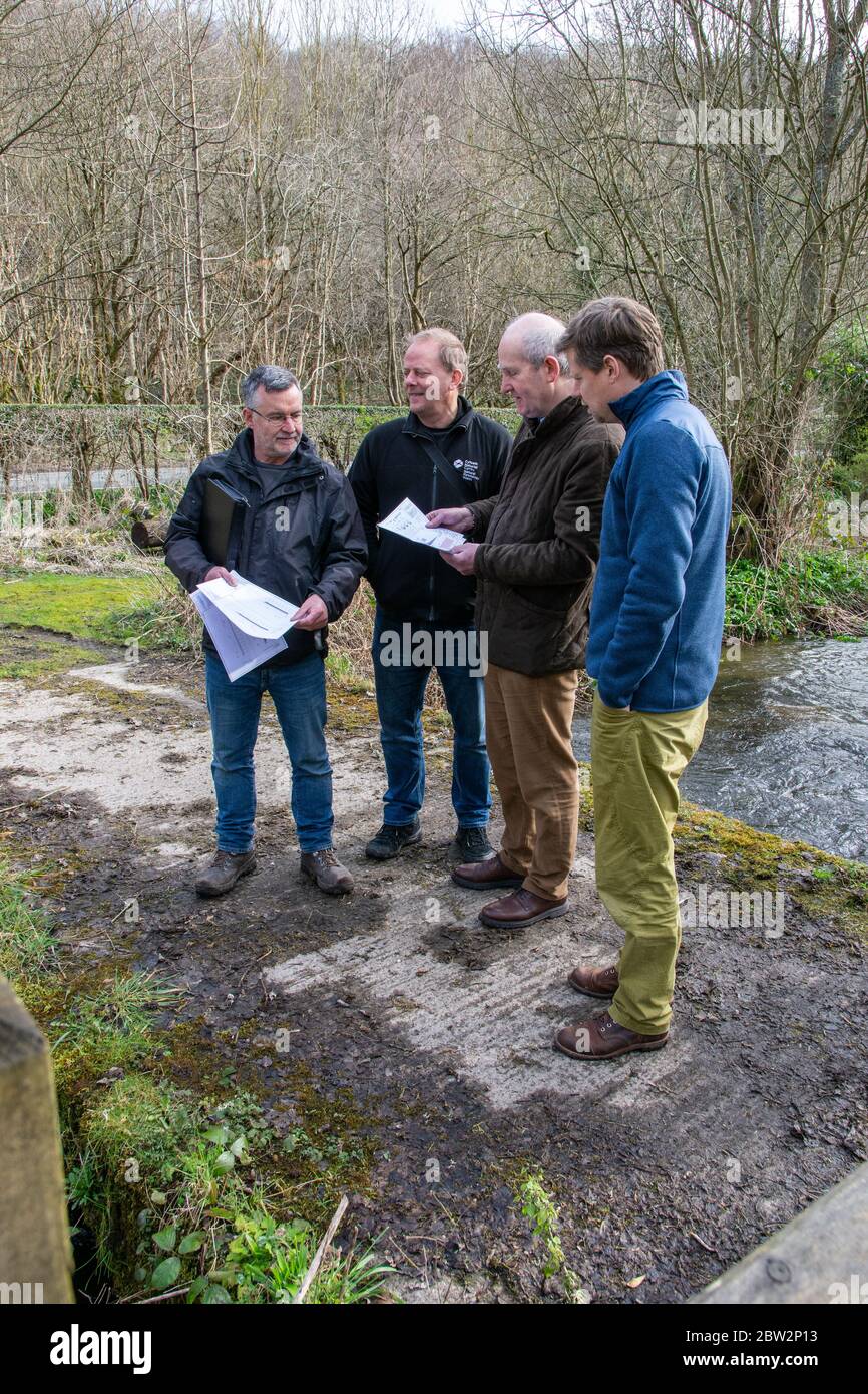 Four men review and sinus plans on white paper standing on a concrete ...