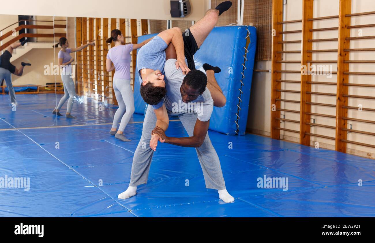 Two young men practicing self defense techniques in sports club Stock ...