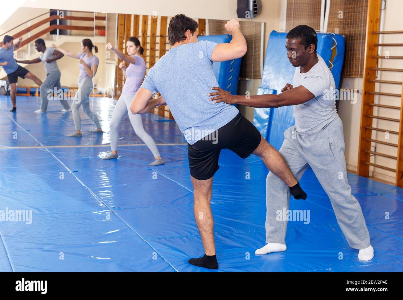Two young men practicing self defense techniques in sports club Stock ...