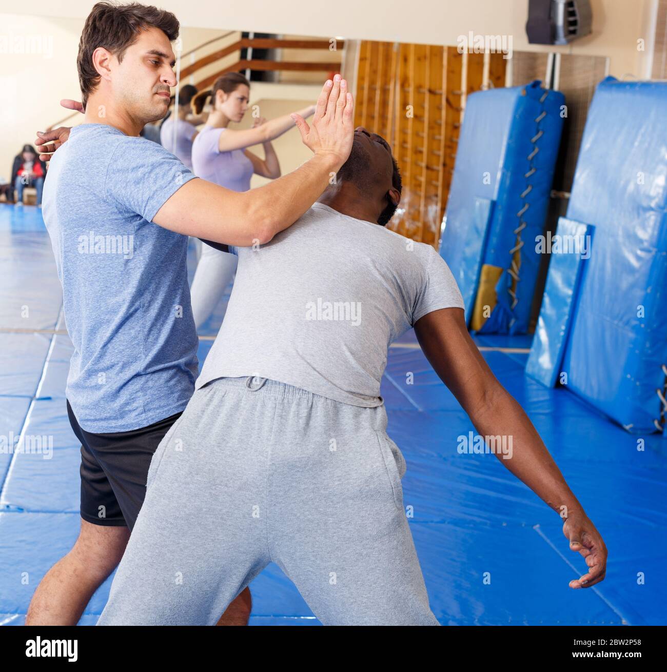 Two young men practicing self defense techniques in sports club Stock ...