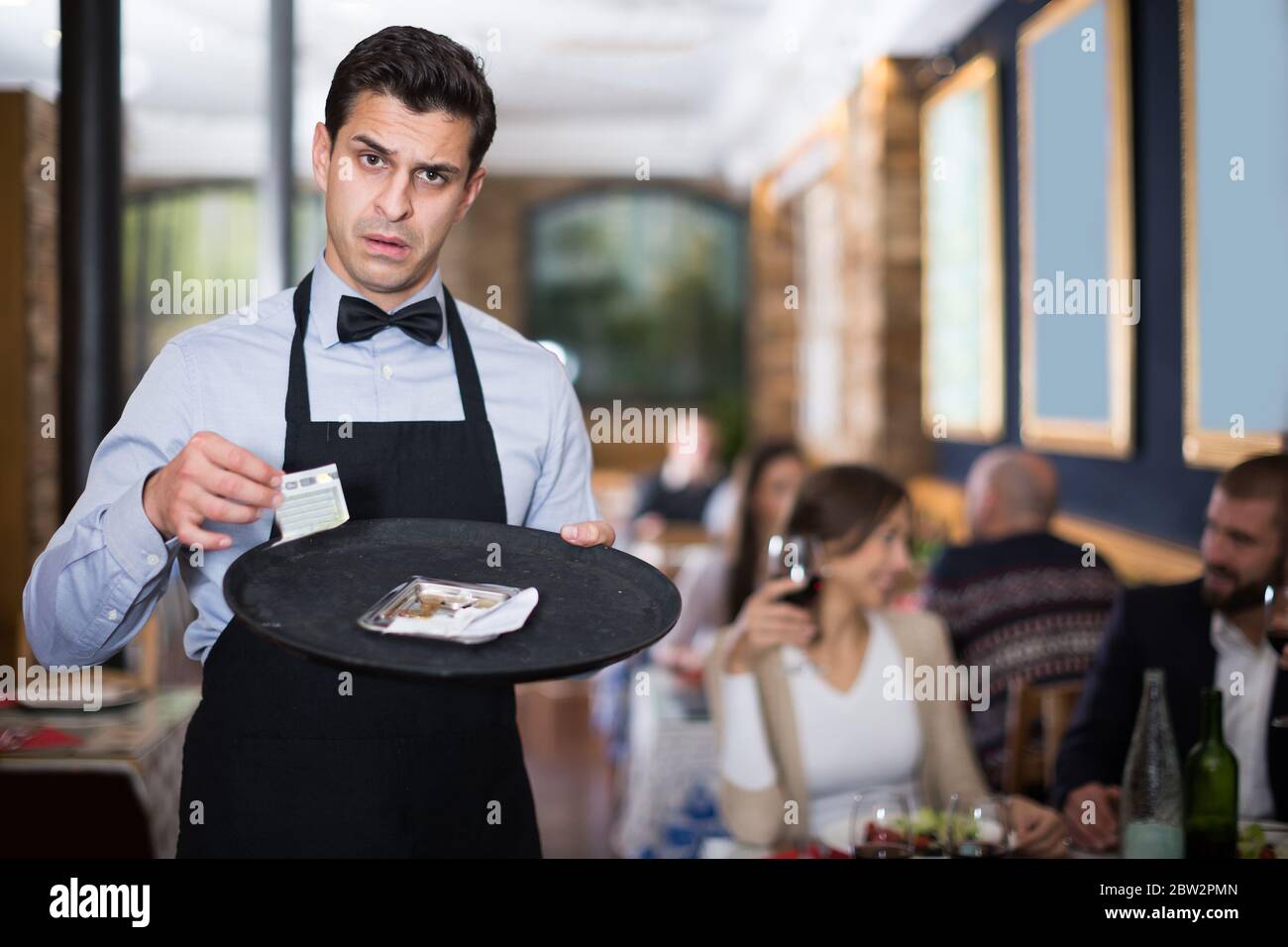 Shocked waiter keeps money to order in a restaurant Stock Photo - Alamy