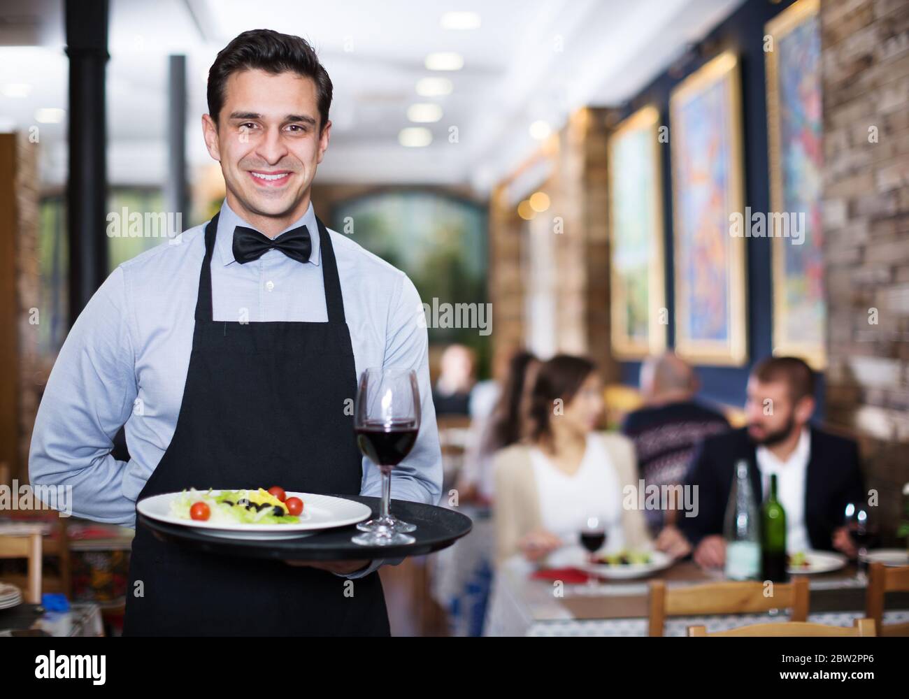 Portrait of smiling waiter with serving tray at a restaurant Stock ...