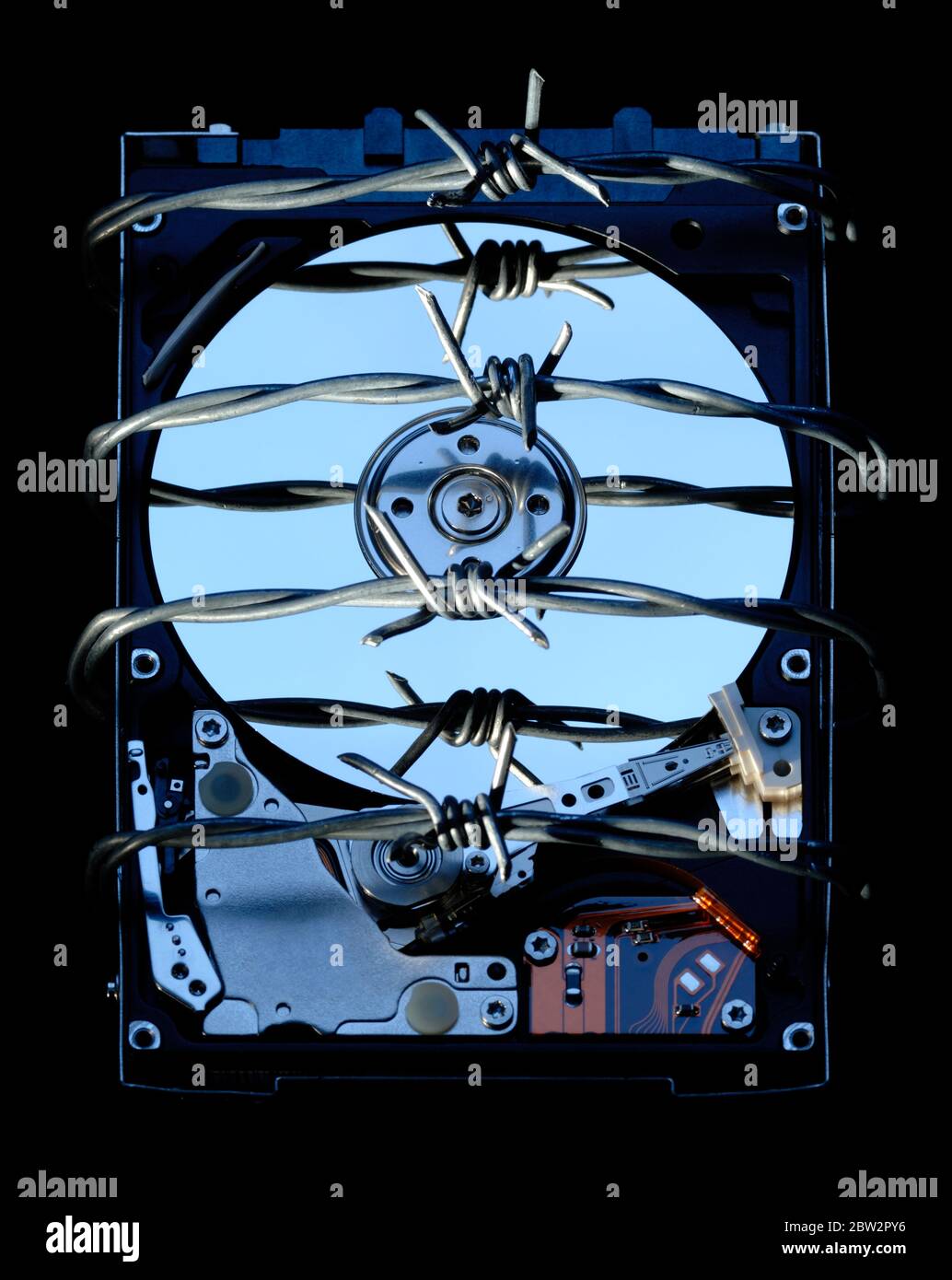 A computer hard drive surrounded with barbed wire Stock Photo - Alamy