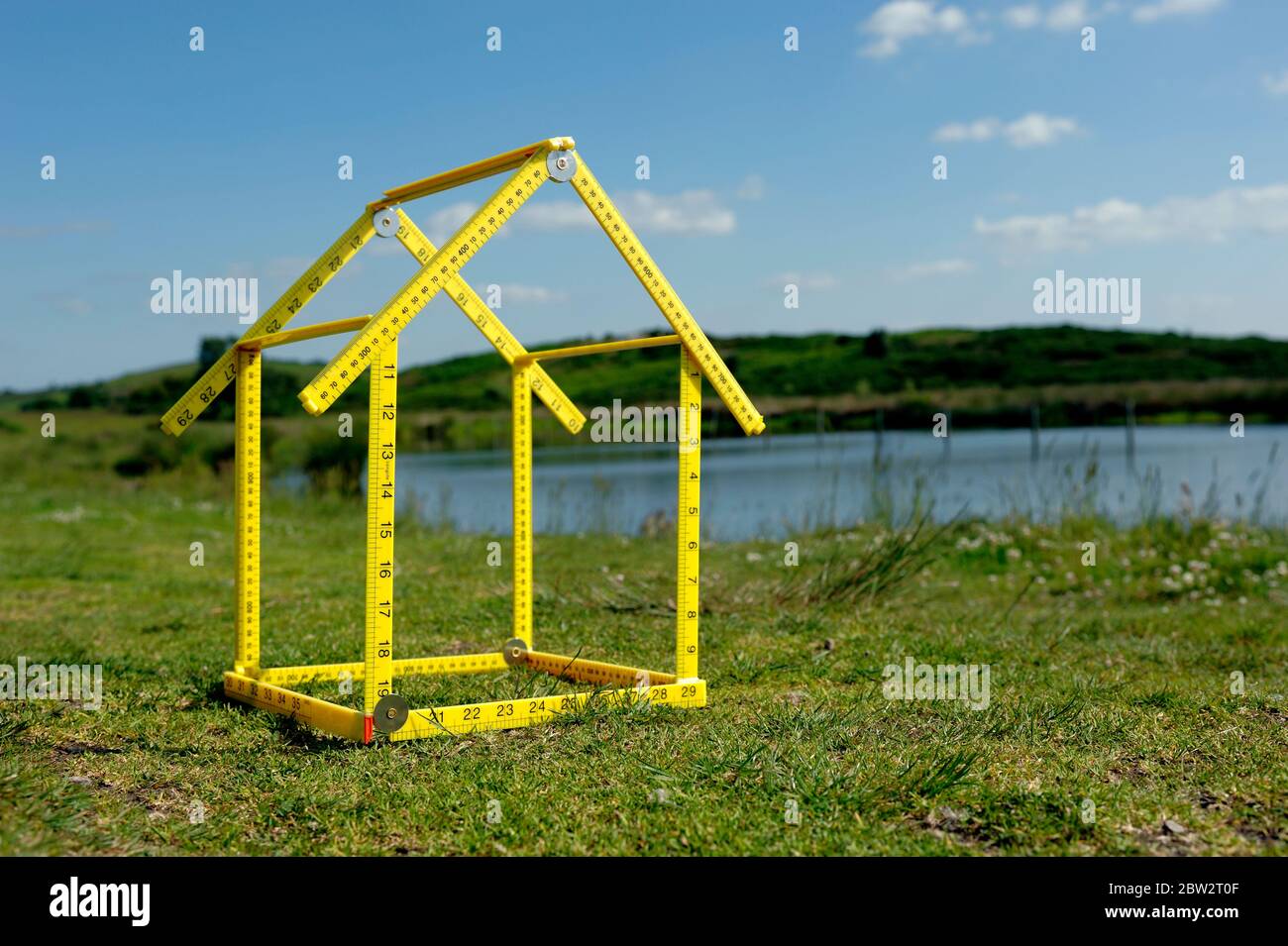 A house shape positioned on a plot of land by a lake Stock Photo - Alamy