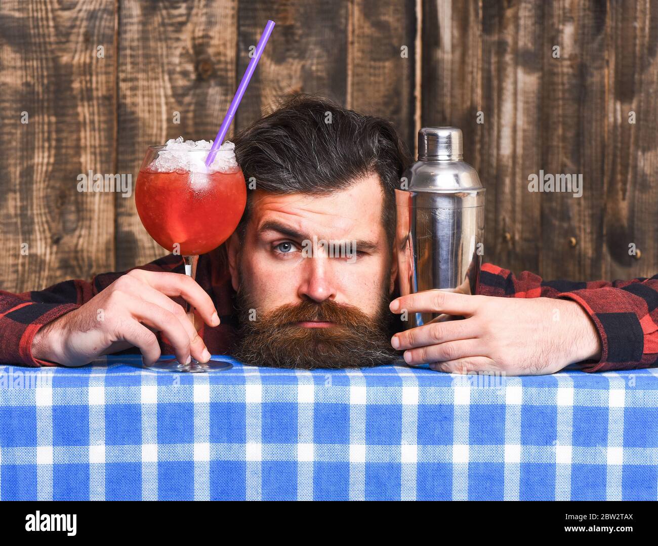 Tired barman concept. Barman with beard and grimace face put head on ...