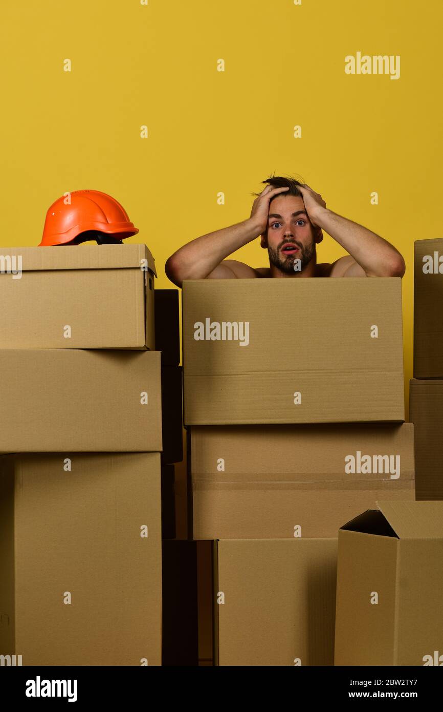 Delivery and moving concept. Macho with scared face has helmet. Man ...