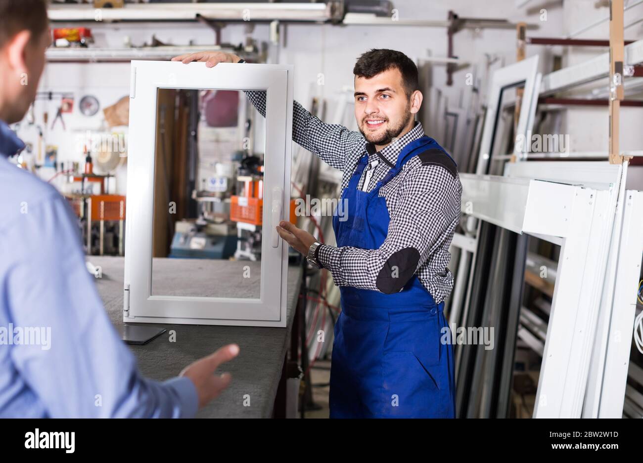 Production smiling worker in coverall demonstrating different PVC ...