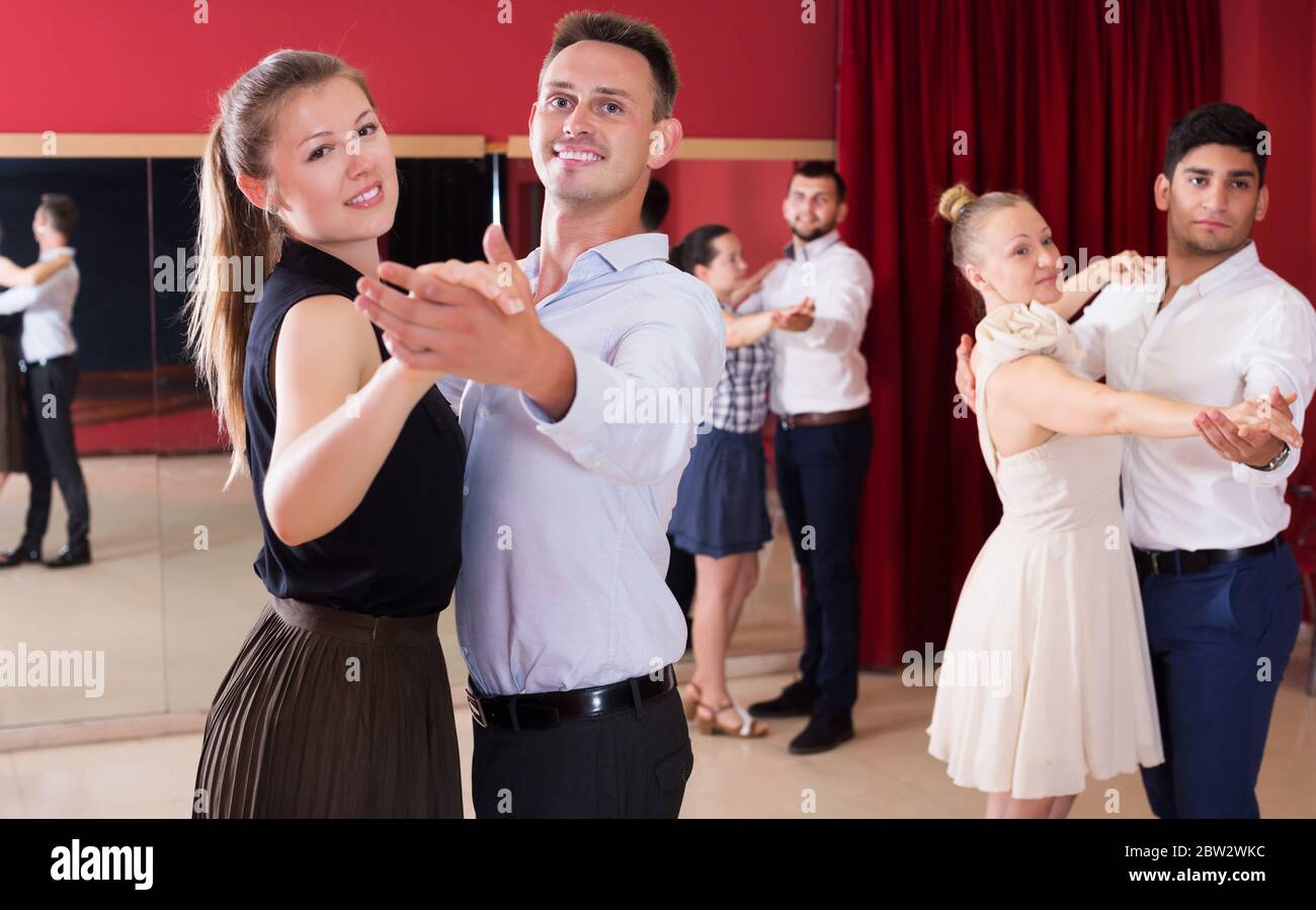 Portrait of happy people dancing together slow ballroom dances in pairs ...